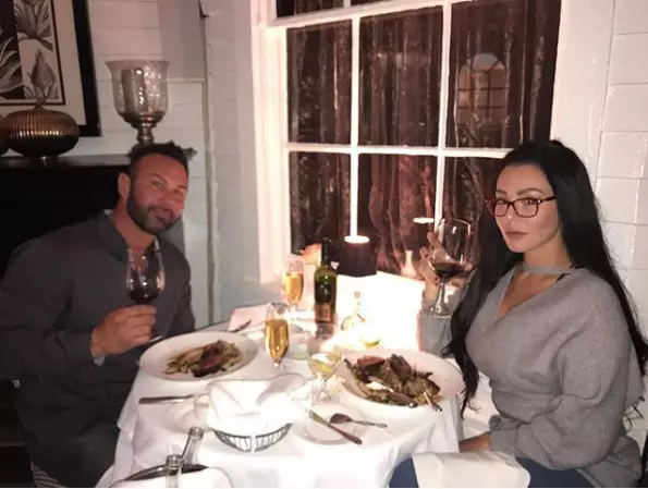 JWoww आणि Roger एकत्र, JWoww राखाडी स्वेटर घातलेले आणि वाईन पीत आहेत