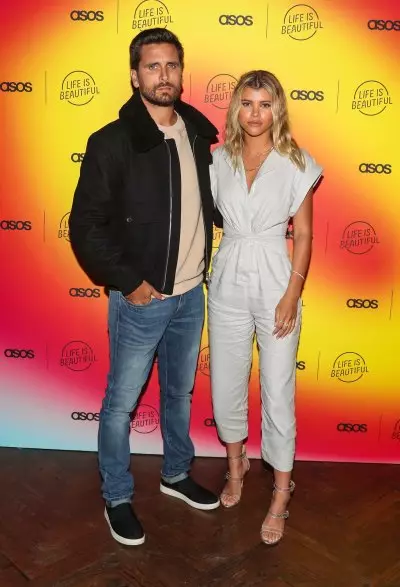 Scott Disick usa jeans e jaqueta com Sofia Richie em macacão cinza