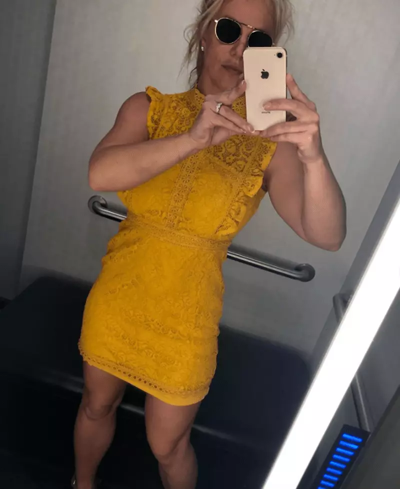 Бритни Спирс облечена во жолт фустан и слика во огледало