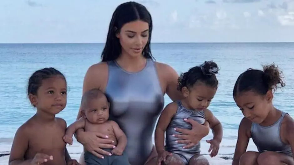Kim Kardashian og hendes fire børn på stranden iført matchende sølvbadedragter