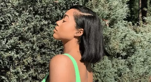 Jordyn Woods posiert in einem limonengrünen Bikini mit kurzen, schwarzen Haaren.