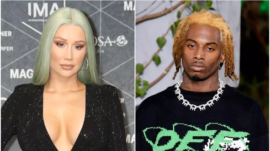 Iggy Azalea turi mėlynus, žalius plaukus su juoda suknele Playboi Carti vaikšto per baltą Louis Vuitton mados šou