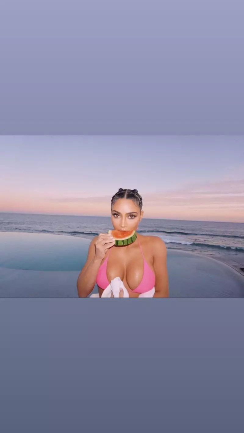 Kim Kardashian draagt een felroze stringbikini