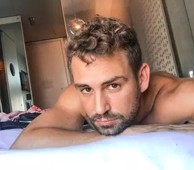 Nick Viall in bed in een hotel en maakt een selfie