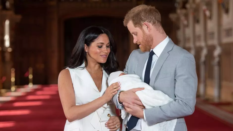 Meghan Markle i hvitt og prins Harry i dress med sin nye baby