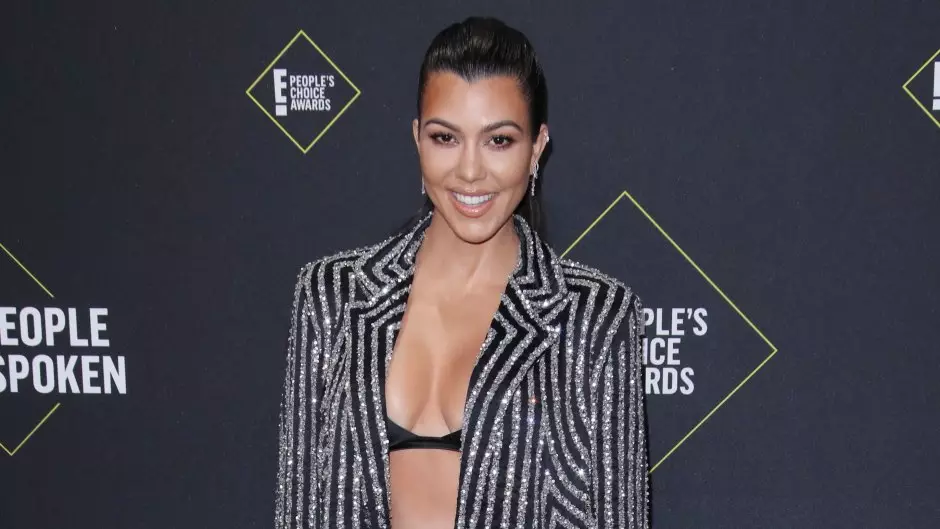 Kourtney Kardashian rẹrin musẹ ni Aṣọ Dinla Sparkly ati Black Bra Top