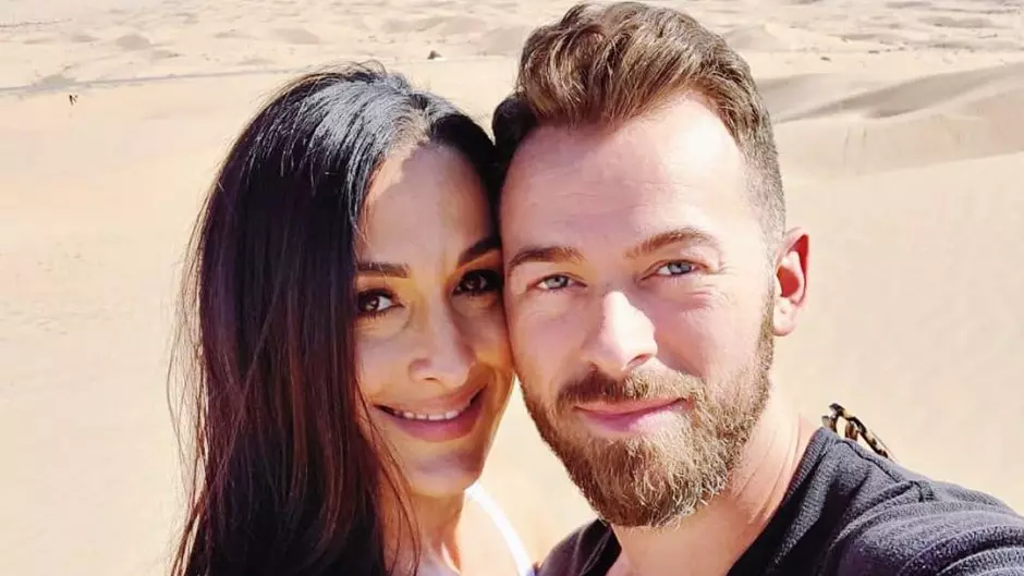 Stolte forældre Nikki Bella og Artem Chigvintsev pakker på PDA'en, mens han laver aftensmad