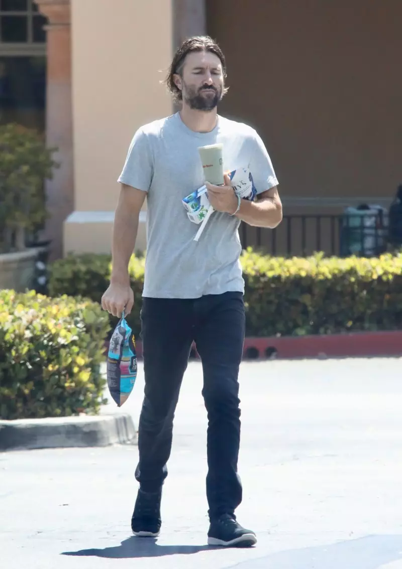 Ο Brandon Jenner βγαίνει για τρέξιμο μπλε πουκάμισο και τζιν κρατώντας σνακ