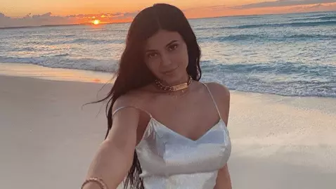 Kylie Jenner në plazh me një muzg në sfond