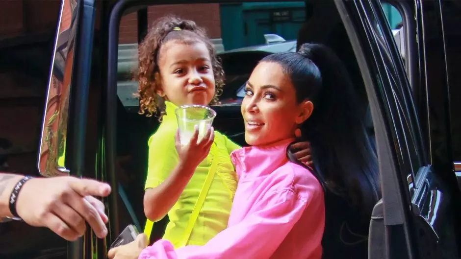 Kim Kardashian dėvi visiškai rožinę spalvą, laikydamas dukrą šiaurėje, kuri yra visiškai žalia