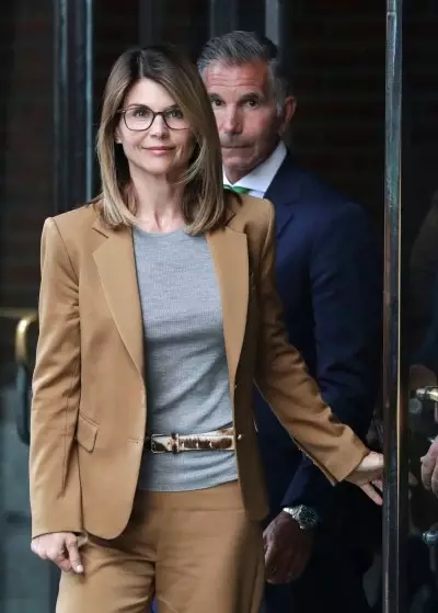 Lori Loughlin, Mossimo Giannulli. Actrița Lori Loughlin, din față, și soțul, designerul de îmbrăcăminte Mossimo Giannulli, din spate, pleacă de la tribunalul federal din Boston, după ce s-au confruntat cu acuzații într-un scandal de luare de mită la nivel național la colegiu