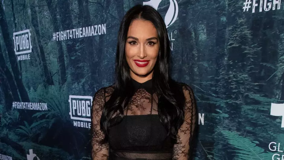 Nikki Bella smiler i rød læbestift og sort gennemsigtig blondekjole