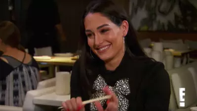 Nikki Bella glimlag terwyl sy soesji eet