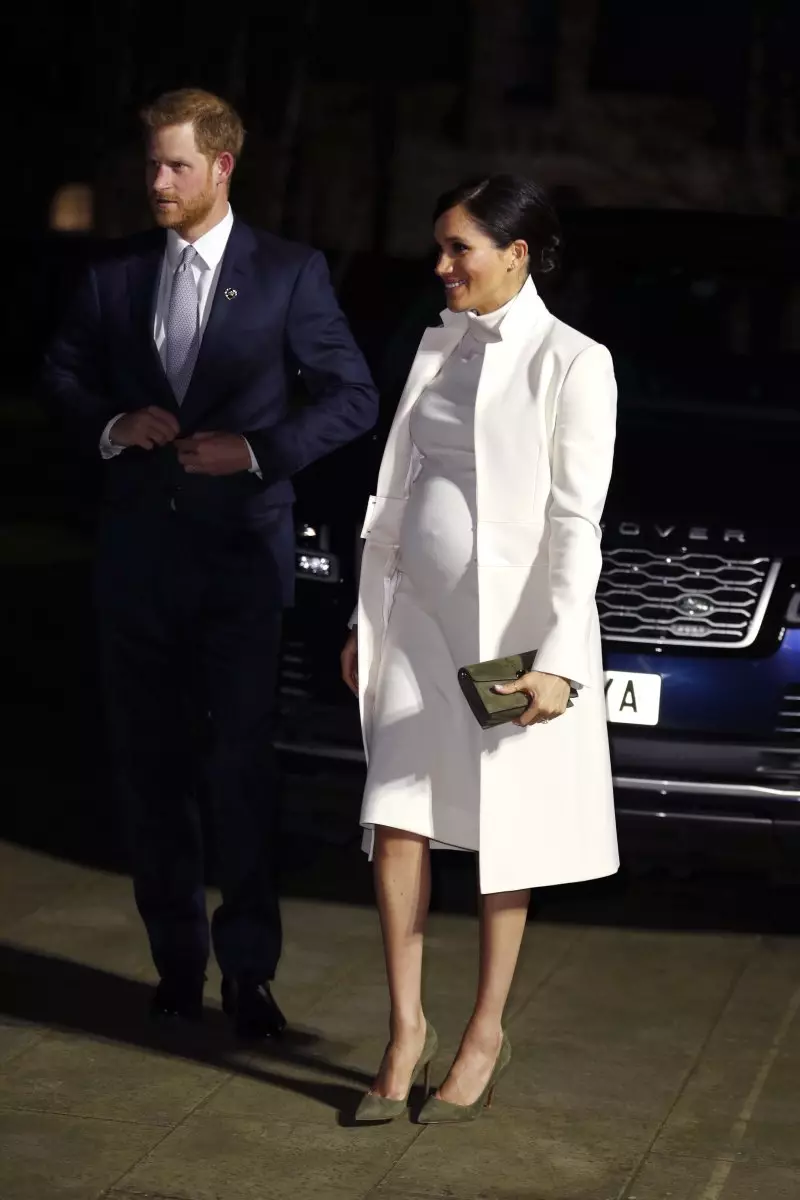 Meghan Markle in abito bianco con il principe Harry in abito blu navy