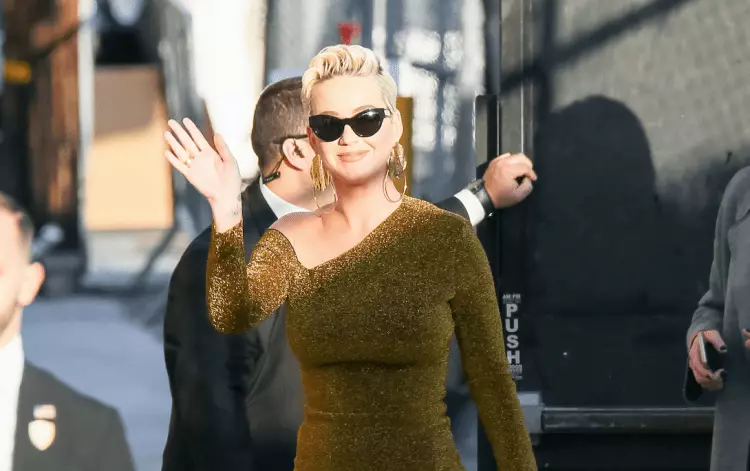 Katy Perry nganggo klambi emas sing nyenyet karo kacamata ireng