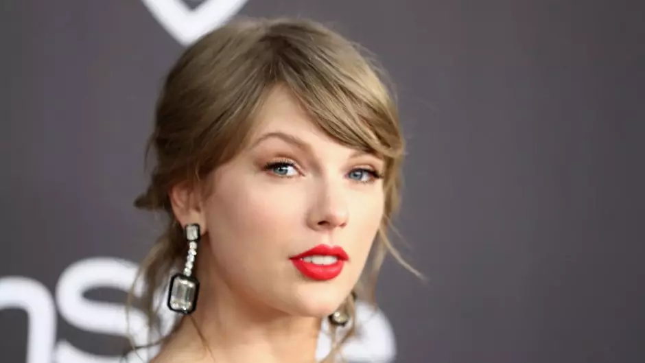 Taylor swift sateenkaarihousut ja vaaleanpunaiset hiukset iheartradio music Awardsissa