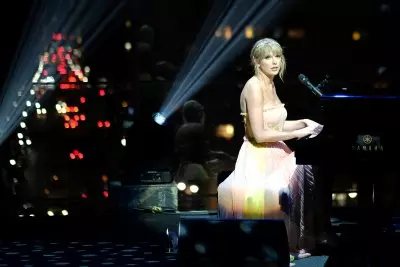 Gala Taylor Swift Time 100 gra na pianinie śpiewając żółtą i różową sukienkę