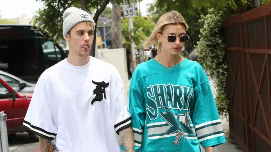 Justin Bieber e Hailey Baldwin camisa de tubarões óculos de sol sem maquiagem de mãos dadas relacionamento matrimonial