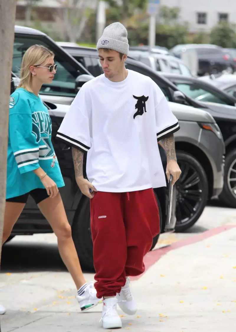 Justin Bieber große rote Hose übergroßes weißes T-Shirt und Hailey Baldwin Sharks Jersey schwarze Shorts Sonnenbrille