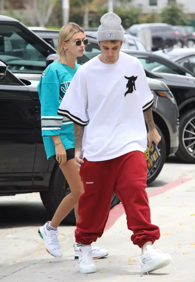 Justin Bieber große rote Hose übergroßes weißes T-Shirt und Hailey Baldwin Sharks Jersey schwarze Shorts Sonnenbrille