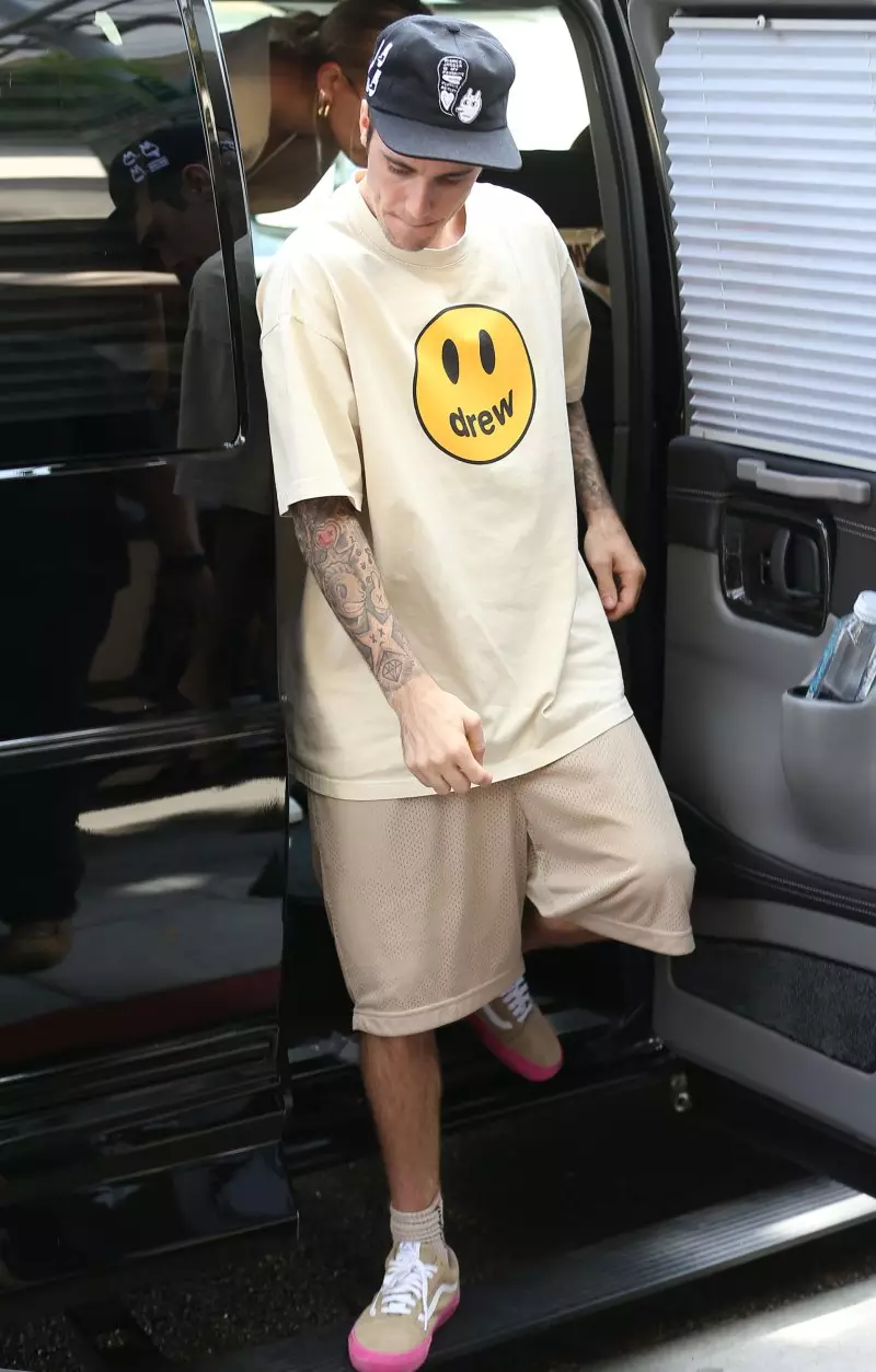 Justin Bieber trägt ein beiges Drew-House-T-Shirt und beige Shorts mit Hailey Baldwin in Jeans-Shorts, einem weißen Tanktop und einer beige Jacke