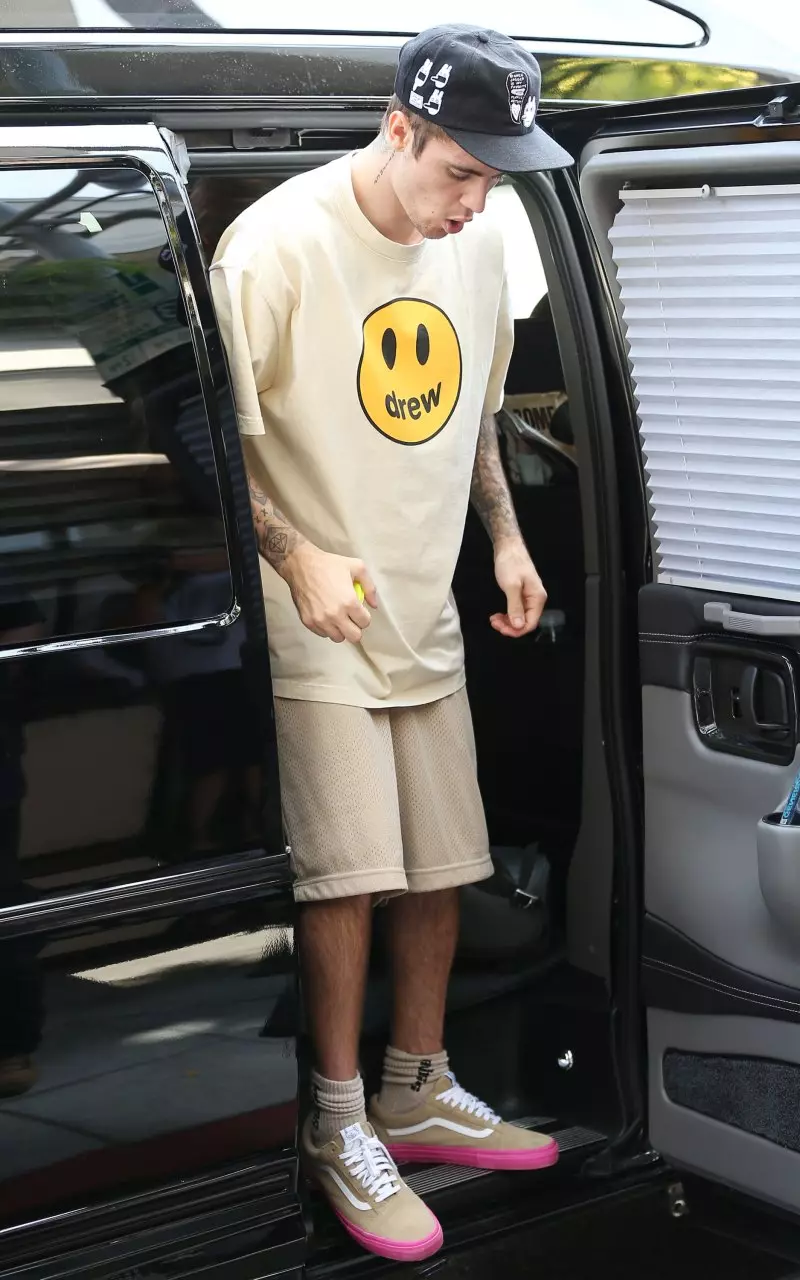 Justin Bieber indossa una maglietta Tan Drew House e pantaloncini marrone chiaro con Hailey Baldwin in pantaloncini di jeans Canotta bianca e giacca marrone chiaro