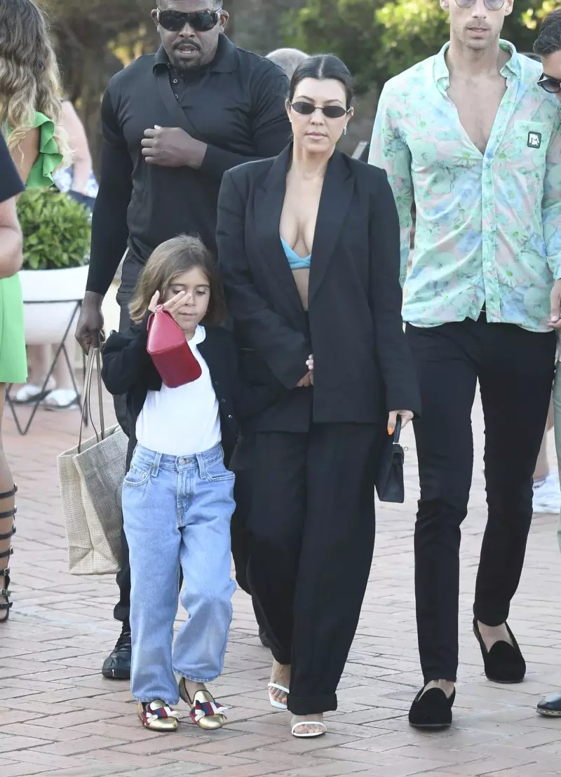 Kourtney Kardashian sai com Penelope Disick na Itália vestindo sutiã verde e terno preto