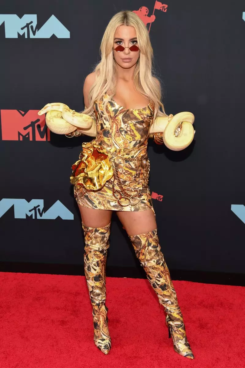 Tana Mongeau har på seg glitrende kjole og støvler på MTV VMA mens hun bærer slange