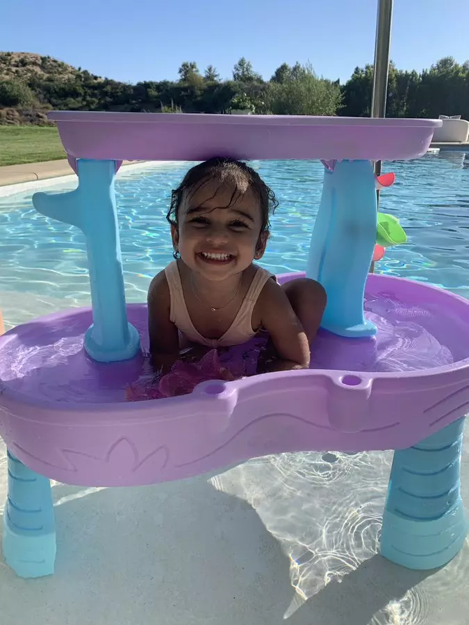 Dream Kardashian sonríe en la piscina mientras se sienta en el juguete de piscina púrpura