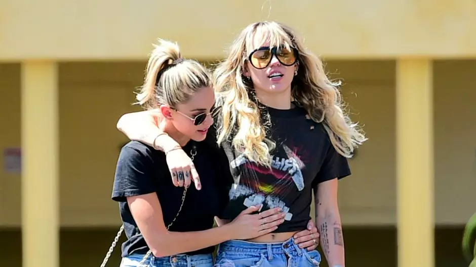 Miley Cyrus går med Kaitlynn Carter iført jeans og sorte t-shirts i Los Angeles