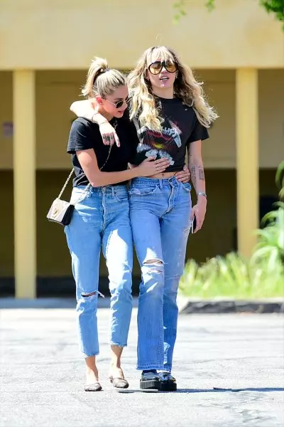 Miley Cyrus går med Kaitlynn Carter iført jeans og sorte t-shirts i Los Angeles
