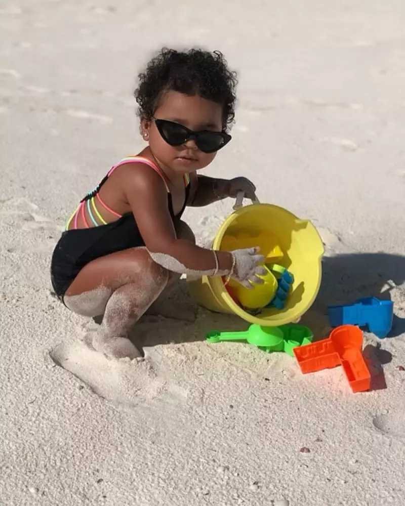 True Thompson leker med en hink på stranden i Bahamas
