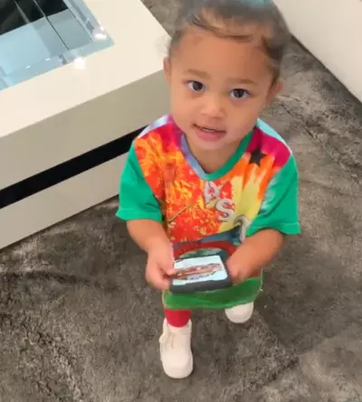 Stormi Webster trägt ein Batik-T-Shirt, während sie Kylie Jenners Rise and Shine hört