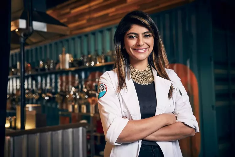 Fatima Ali a cikin Top Chef kitchen tana murmushi tare da haye hannunta