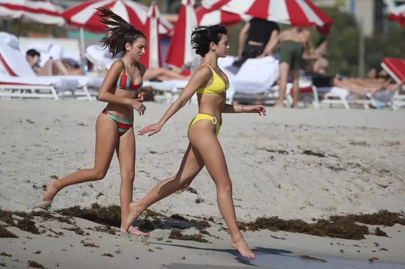 ЕКСКЛУЗИВНО: Певицата Дуа Липа носи жълти бикини, докато се къпе в океана със сестра си в Маями, след което поздравява гаджето си на пясъка