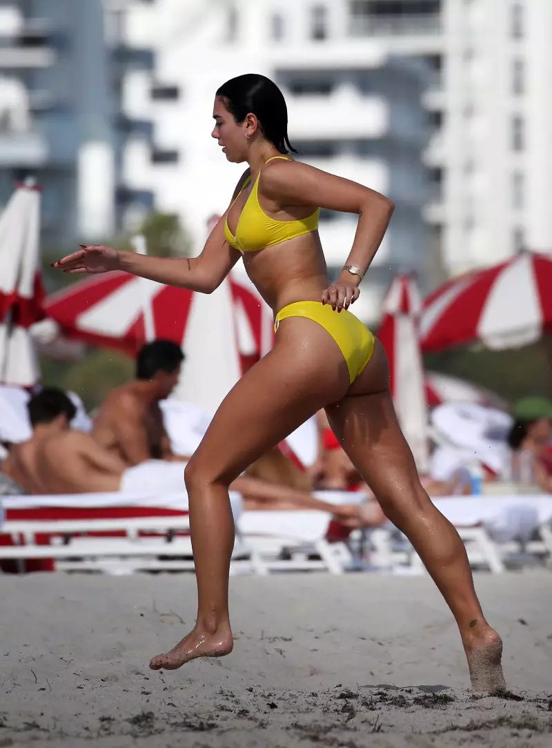 EKSKLUSIVT: Sangerinden Dua Lipa bærer en gul bikini, mens hun tager en dukkert i havet med sin søster i Miami og hilser derefter på sin kæreste i sandet