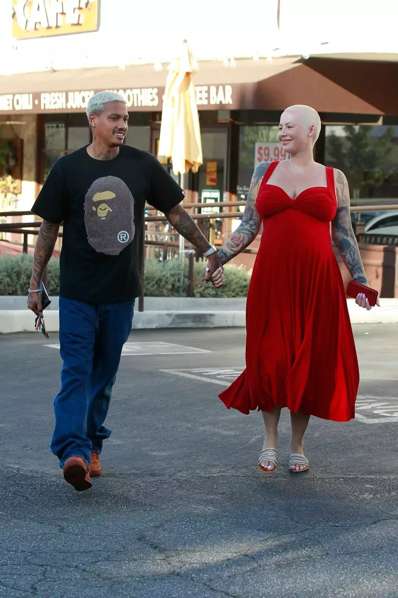 زهرة العنبر الحامل في فستان أحمر طويل مع صديقها ألكسندر إدواردز قبل أسابيع من موعد الاستحقاق