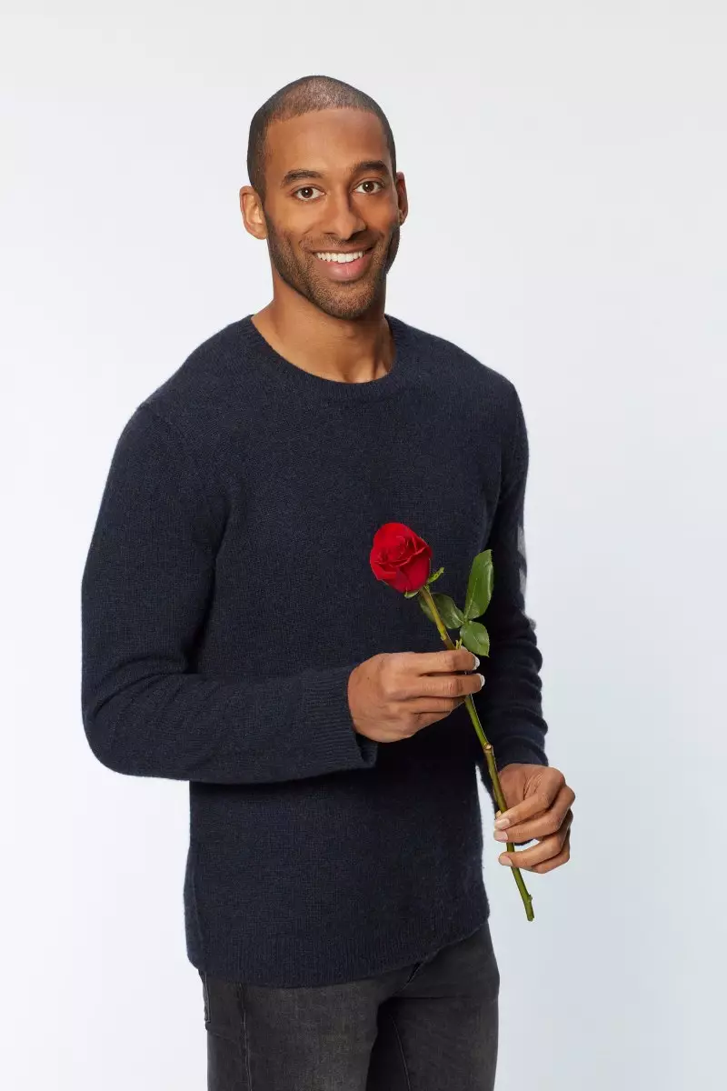 Sarjana Matt James Tersenyum dalam Sweater dan Memegang Mawar