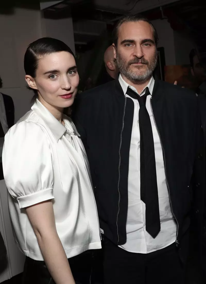 Joaquin Phoenix leva un traxe co brazo sobre a prometida Rooney Mara