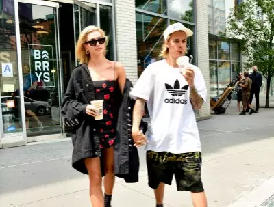 Justin Bieber i Hailey Baldwin agafats de la mà a prop del Bootcamp de Barry a Nova York. Justin està bevent un batut i Hailey porta un abric negre amb un vestit negre