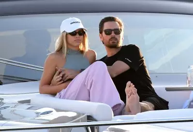 Scott Disick ag caitheamh Léine Dubh Le Sóifia Richie i mBarr Liath agus pants bándearg ar bhád i Miami