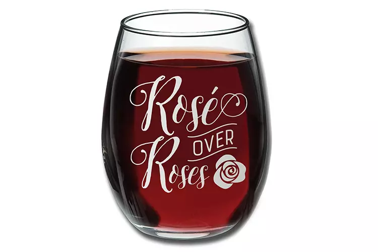 Copo de vinho rosa sobre rosas