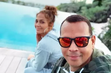 Alex Rodriguez und Jennifer Lopez machen ein Selfie neben einem Pool.