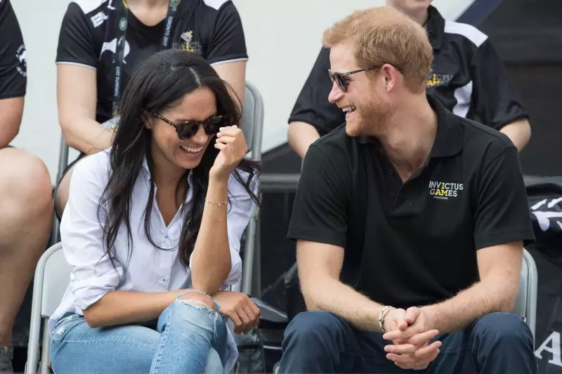 Meghan Markle we şazada Garri ýylgyrýarlar.