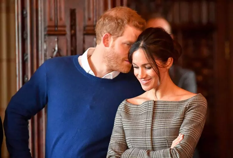 El príncipe Harry susurrando al oído de Meghan Markle