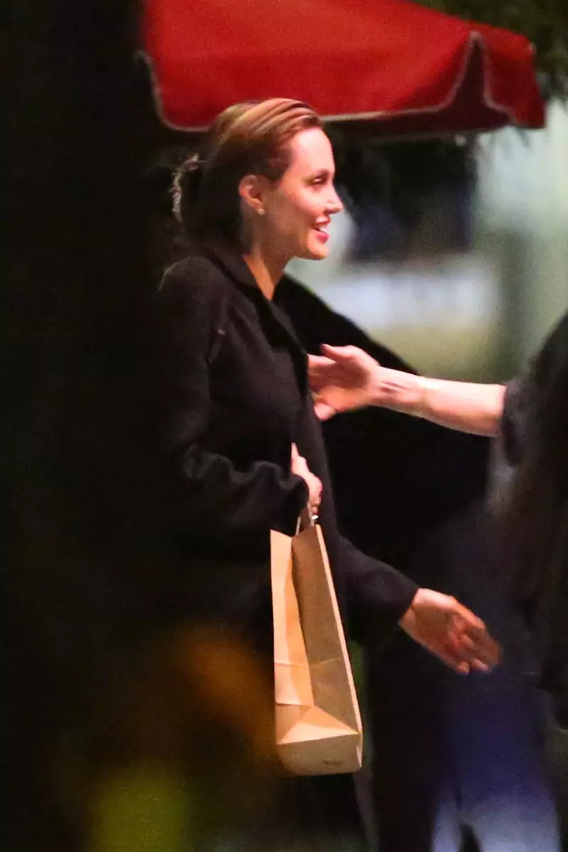 Angelina Jolie viuse a cear cunhas amigas vestindo un abrigo negro