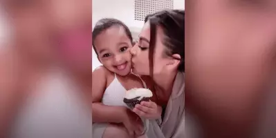 Kim Kardashian Saint-hez, Chicagóhoz és Zsoltárhoz bújik, miközben cupcakes-t csámcsog