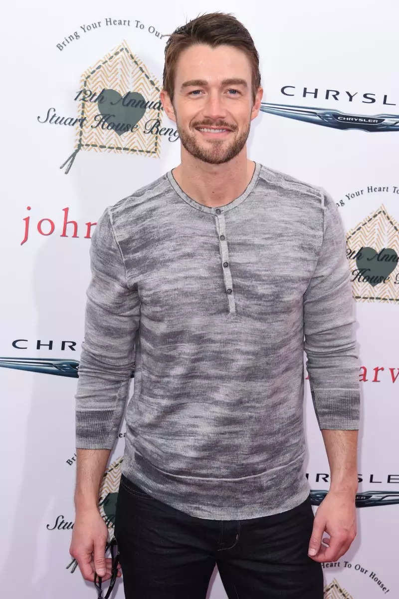 Fostul Robert Buckley al Leei Michele zâmbește în cămașă gri Henley